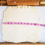 Roll it out on a cutting board to a 12-inch square. Use a measuring ...